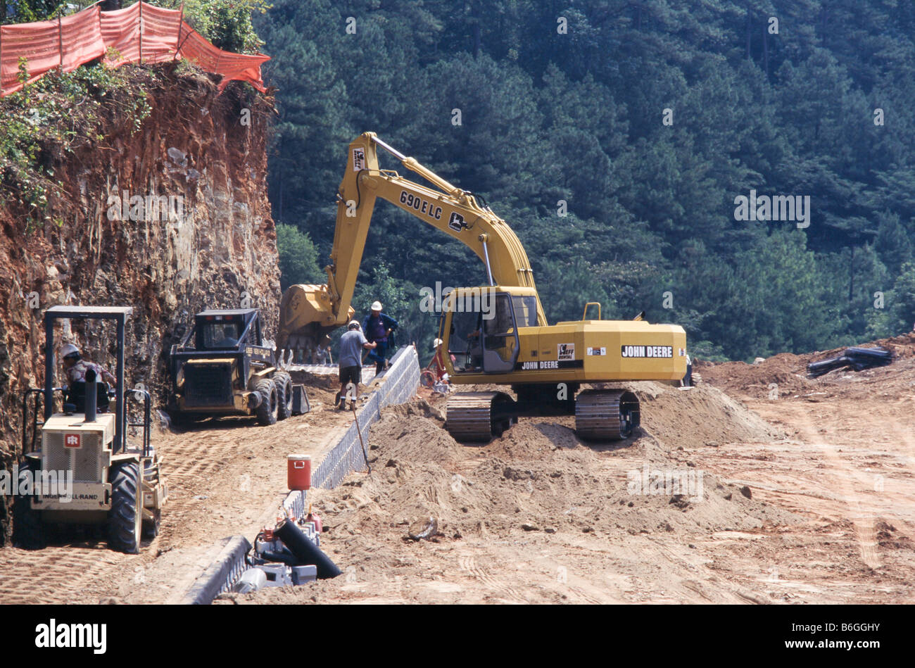 Construction, earth moving equipment, and workers, clearing land ...