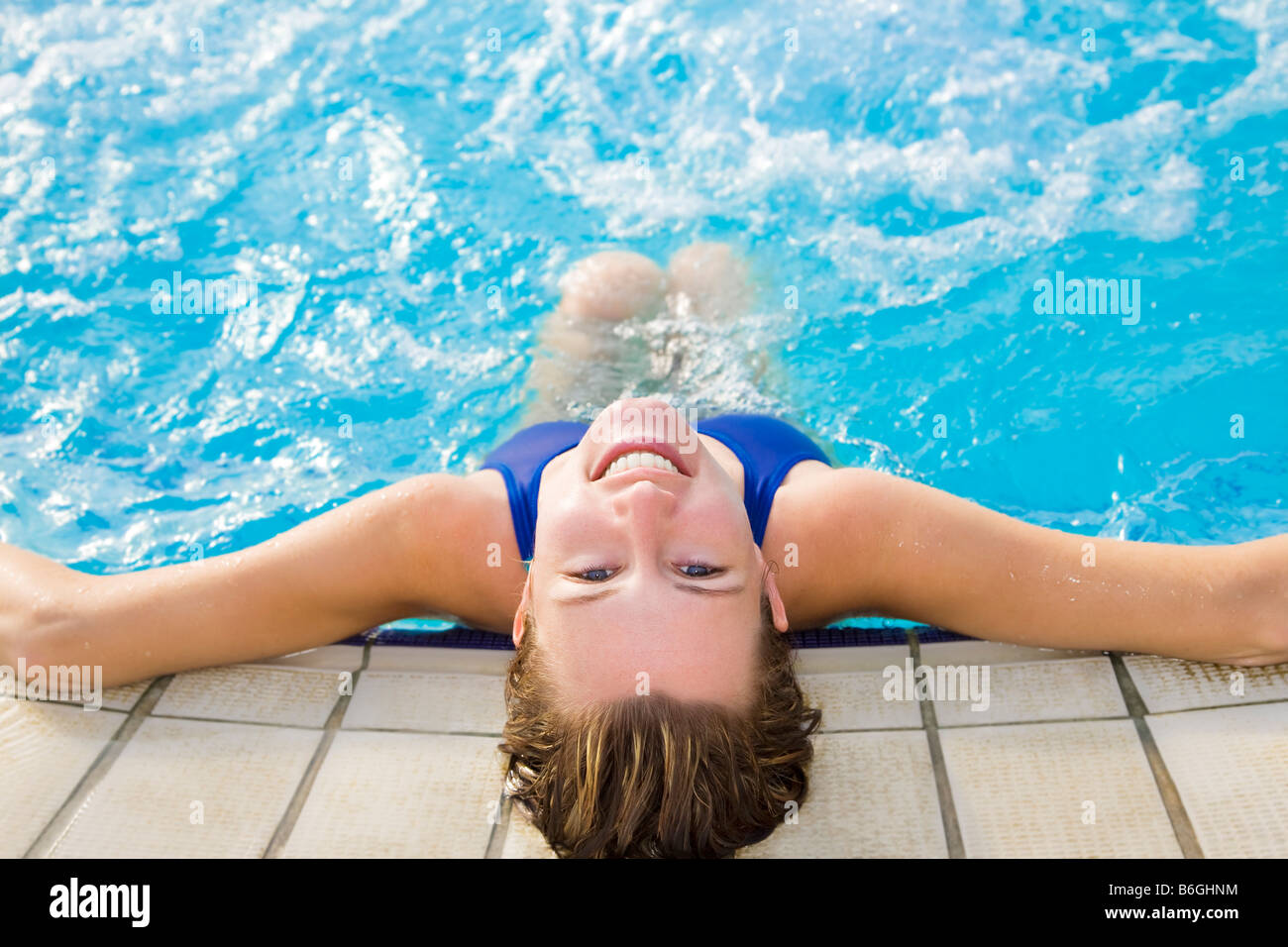 Portrait of young woman sitting in swimming pool rear view Stock Photo ...