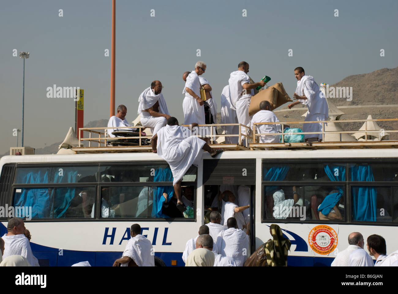 Muslim pilgrims climb and board a bus to travel from the european part ...