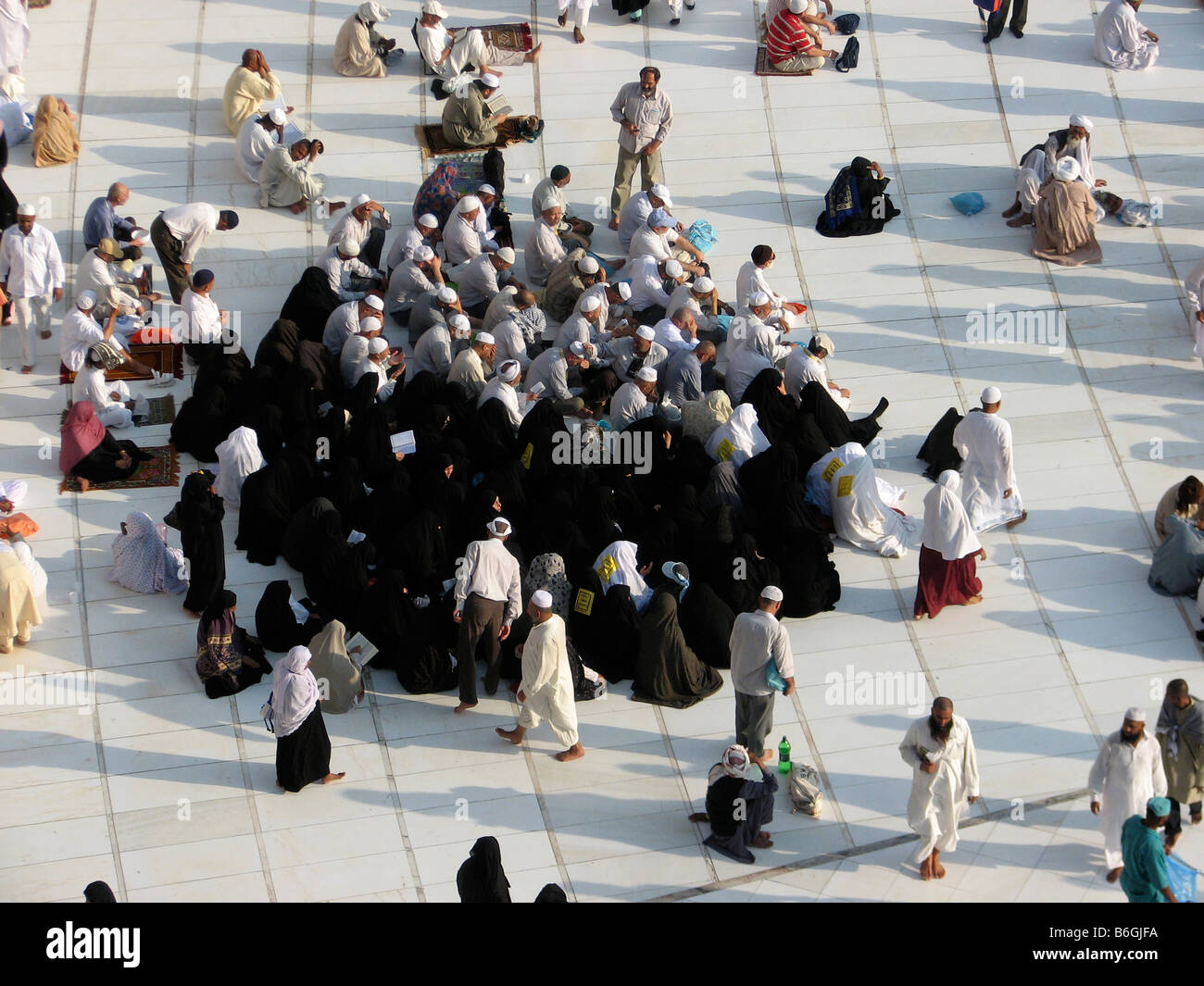 A group of worshippers sitting and praying in front of the Kaba inside ...