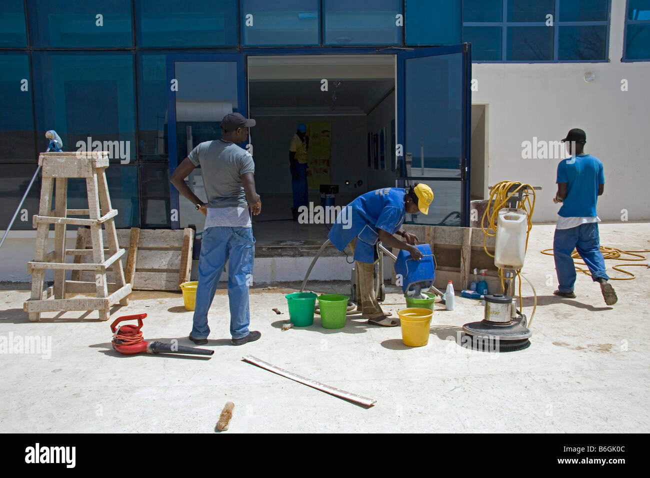 Male and female workers doing maintenance work on new building in Dakar ...