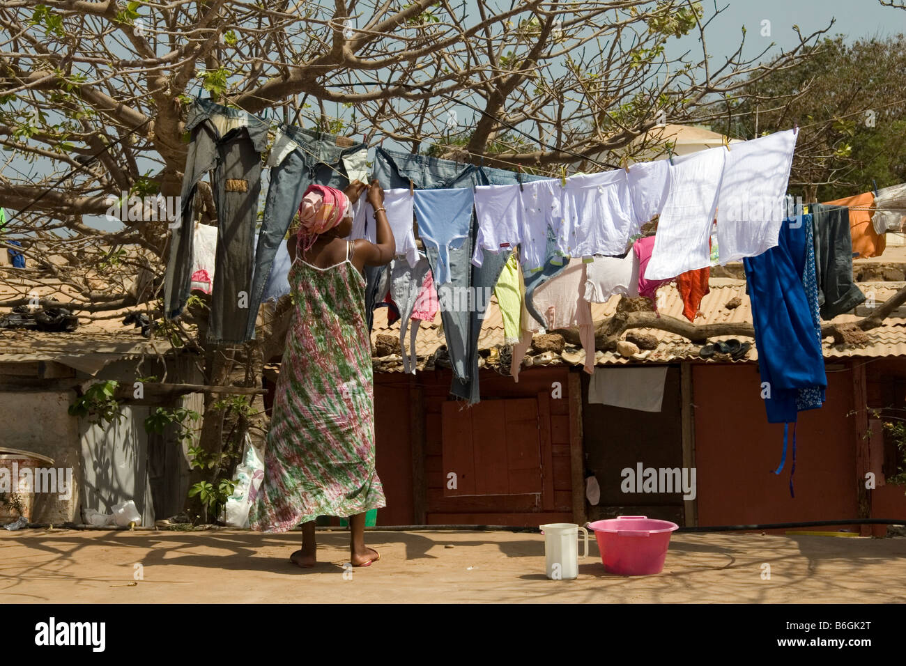 Woman hanging out clothes to dry on washing line Gorée Island Dakar ...
