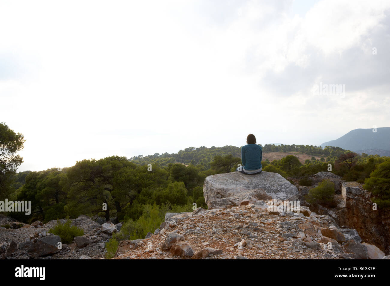Person Sitting alone on a Cliff ridge looking into the distance Stock ...
