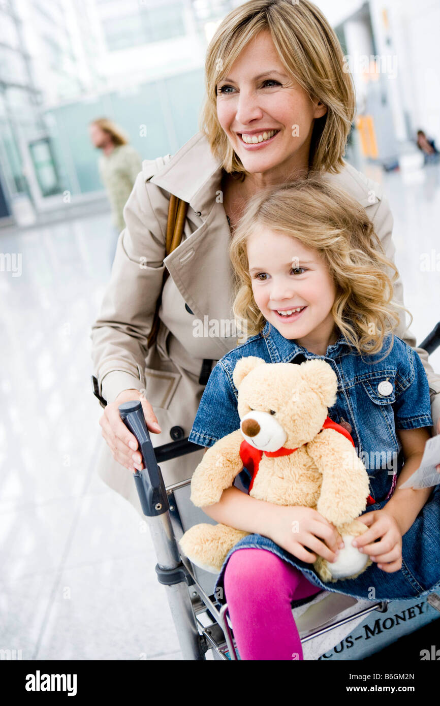 Woman pushing girl riding cart Stock Photo - Alamy