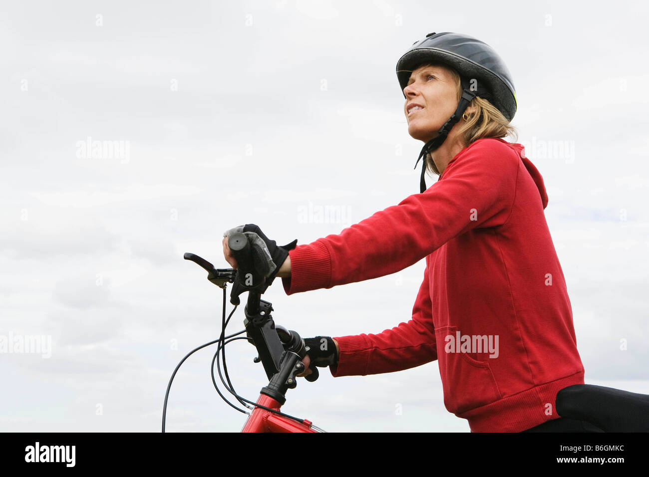 Woman cyclist pushing bicycle Stock Photo - Alamy