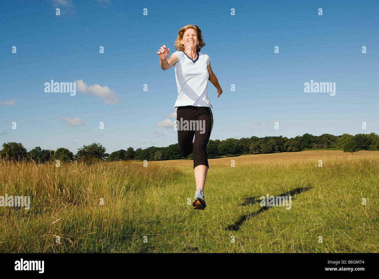 Woman running in field Stock Photo - Alamy