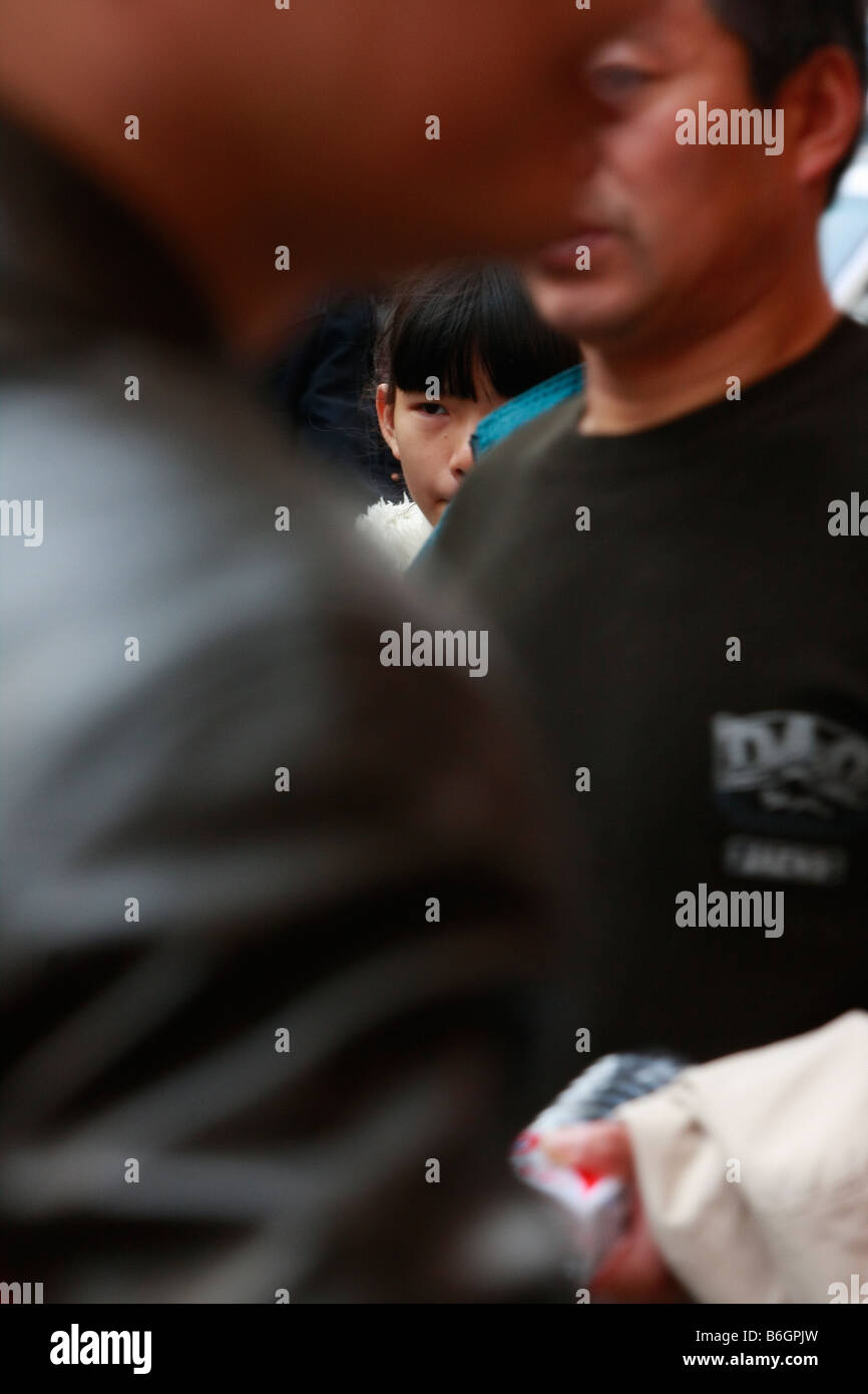 Abstract view of a young chinese girls face through the passing crowd ...