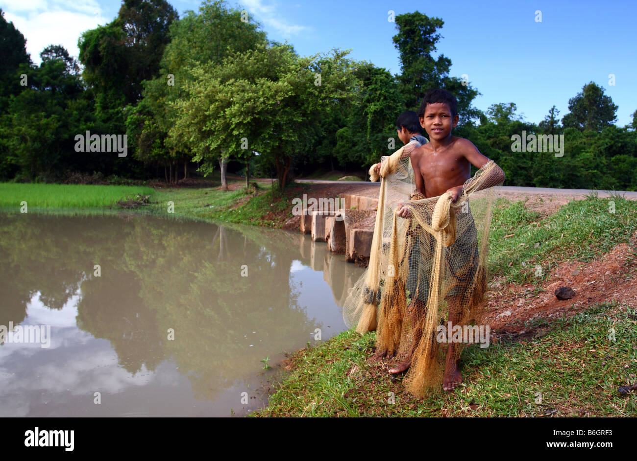 Local young kids fishing casting a net in a pond in the neighborhood of ...