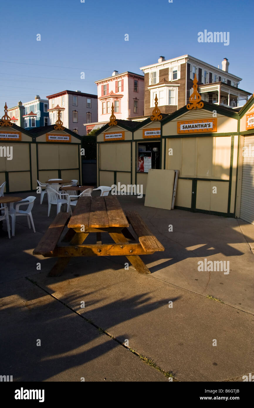 An empty outdoor vendor area with tables, chairs and a picnic table and ...
