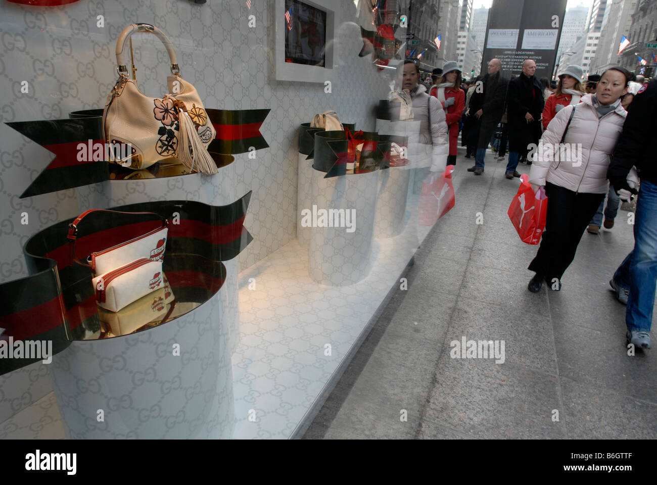 Shoppers pass the window of Gucci on Fifth Avenue in New York ...
