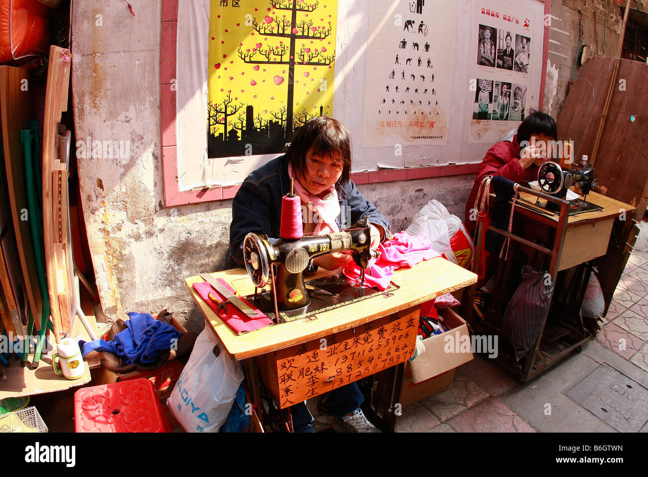 Hard working seamstress works on side streets in China Stock Photo - Alamy