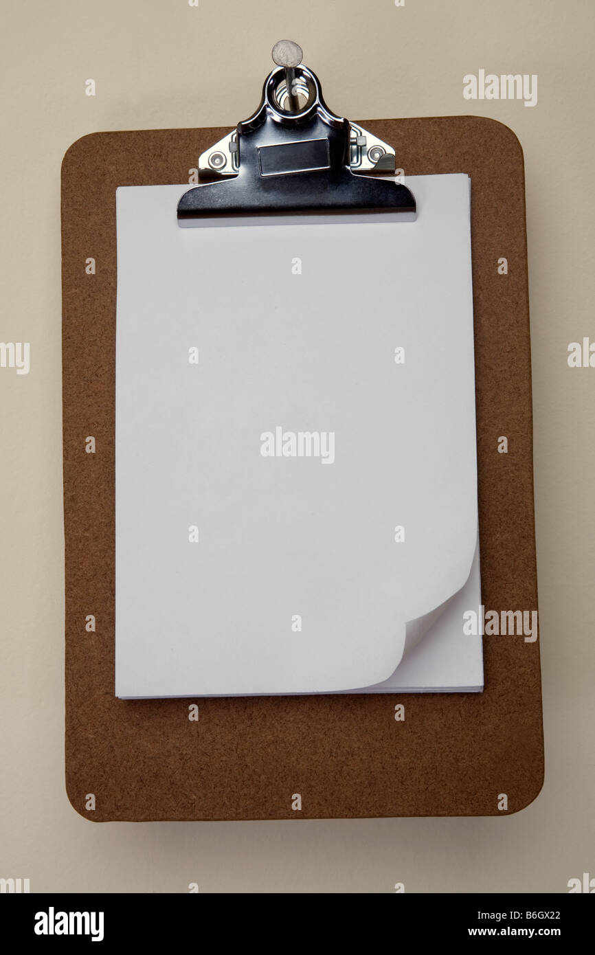 Clipboard with blank paper hanging from nail on a wall Stock Photo - Alamy