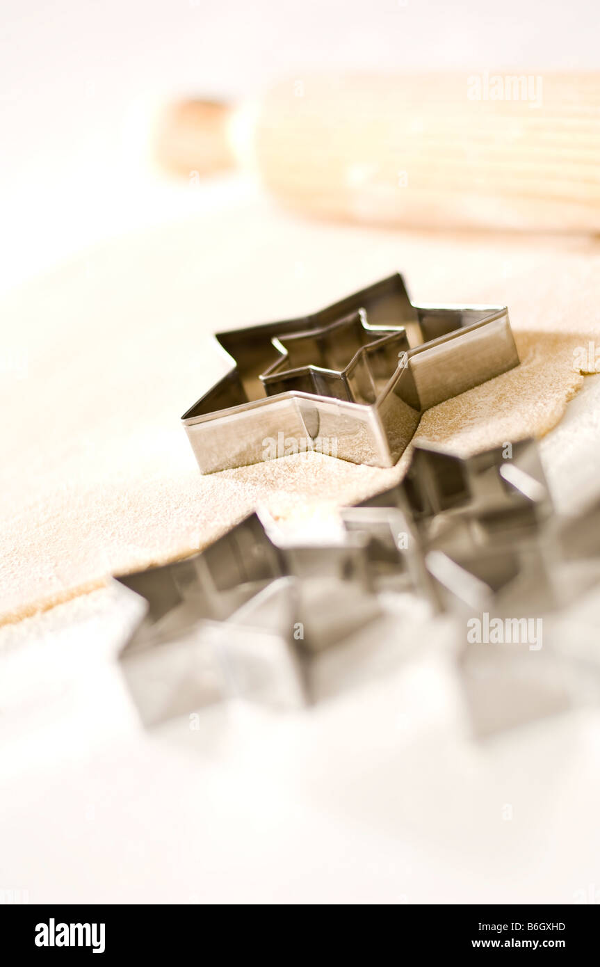 Star-shaped ginger biscuits being stamped out with cookie cutter. Then ...