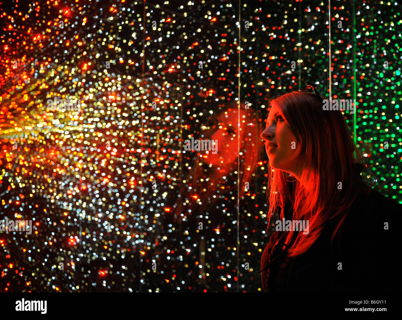 Girl stares into Infinity light tunnel Stock Photo - Alamy