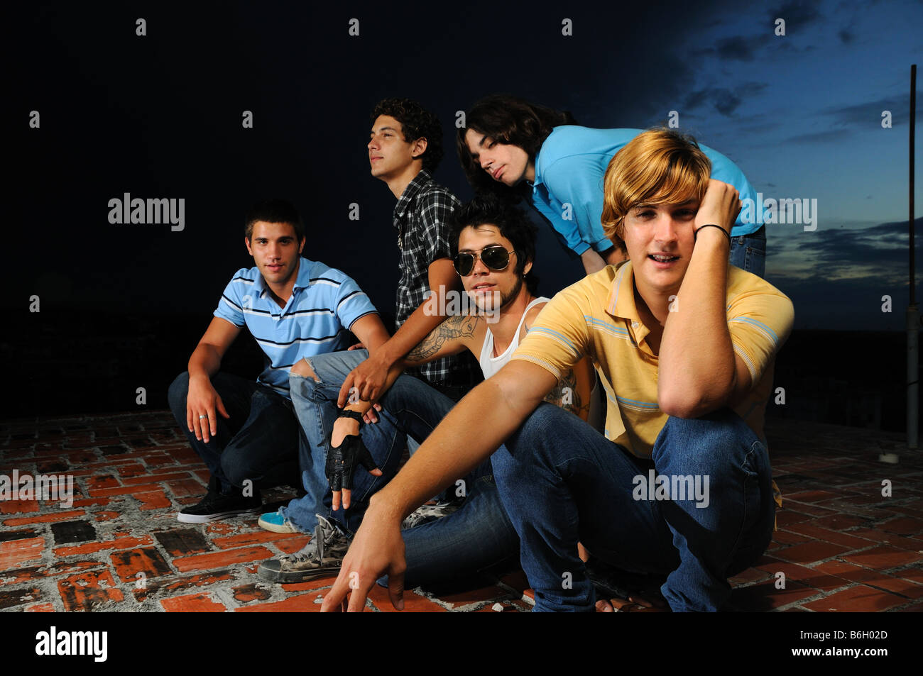 Portrait of young trendy group of male friends standing with attitude ...