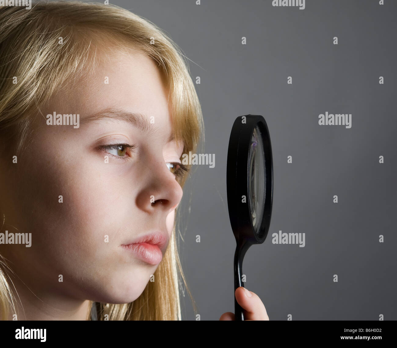 Child looking through a magnifying glass Stock Photo - Alamy