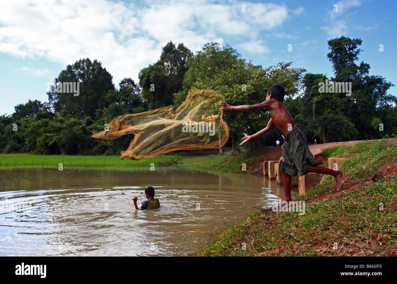 Local young kids fishing casting a net in a pond in the neighborhood of ...