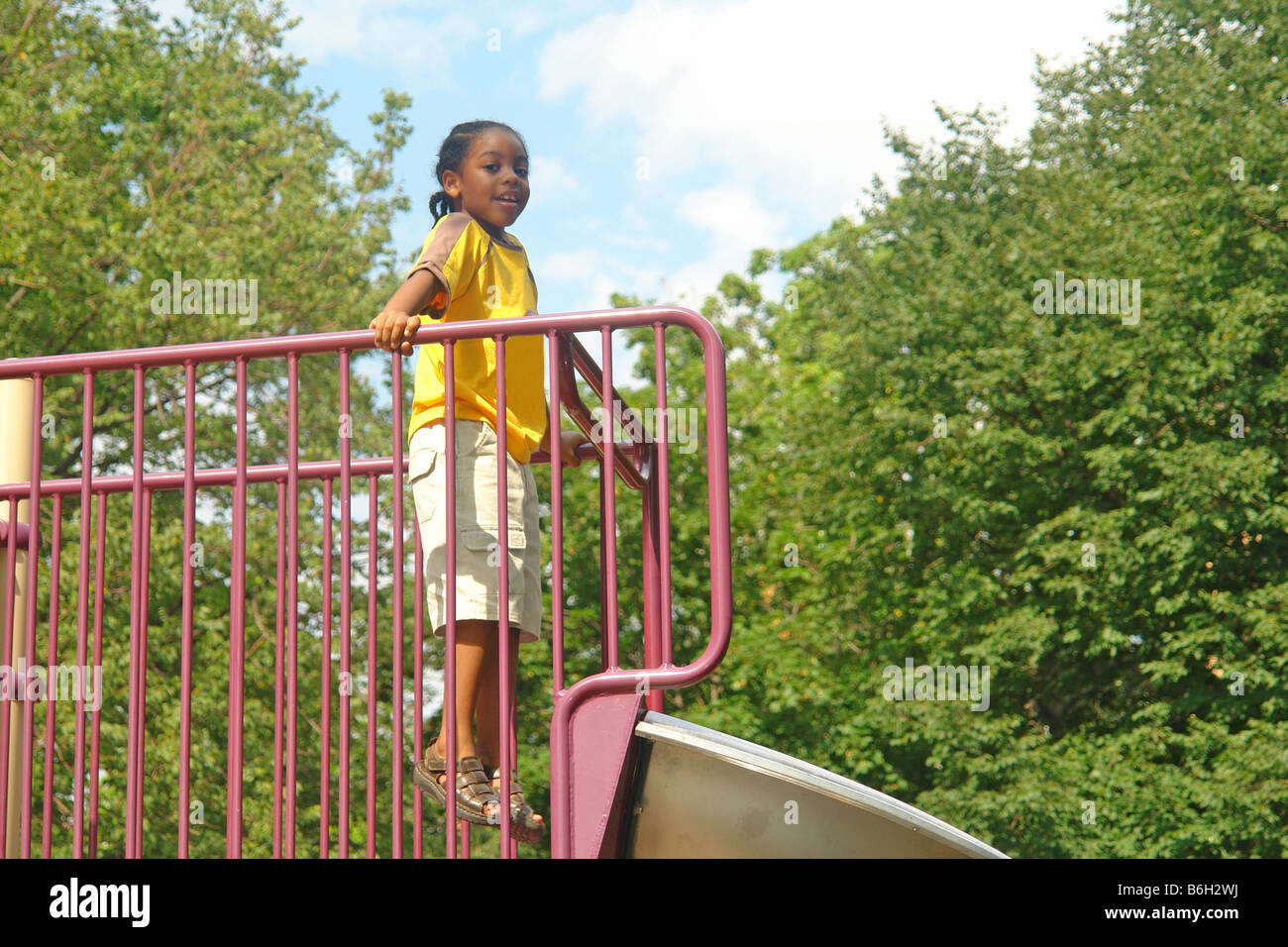 Young Boy Playing on playground equipment Stock Photo - Alamy