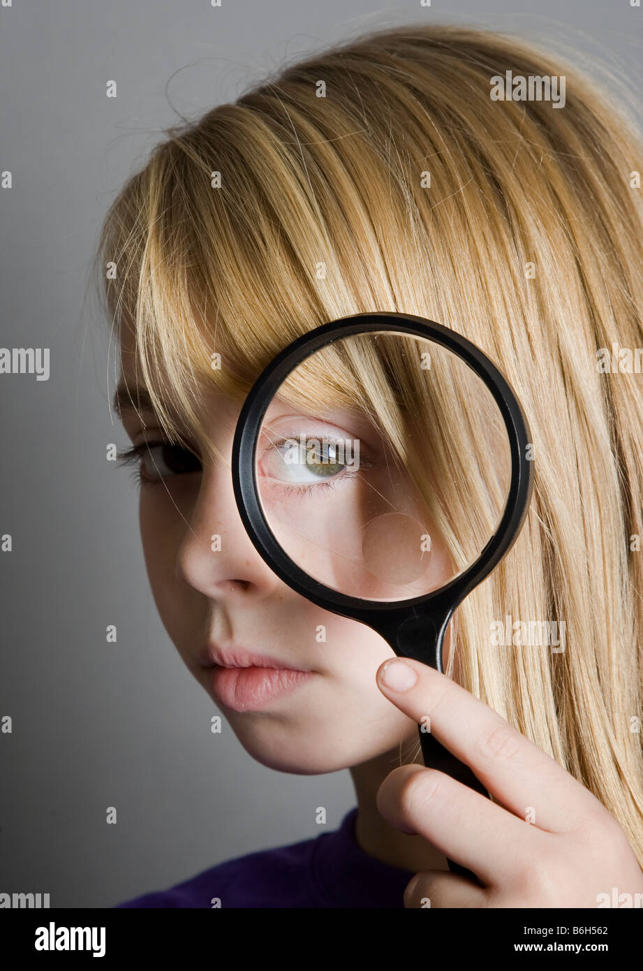 Child looking through a magnifying glass Stock Photo - Alamy
