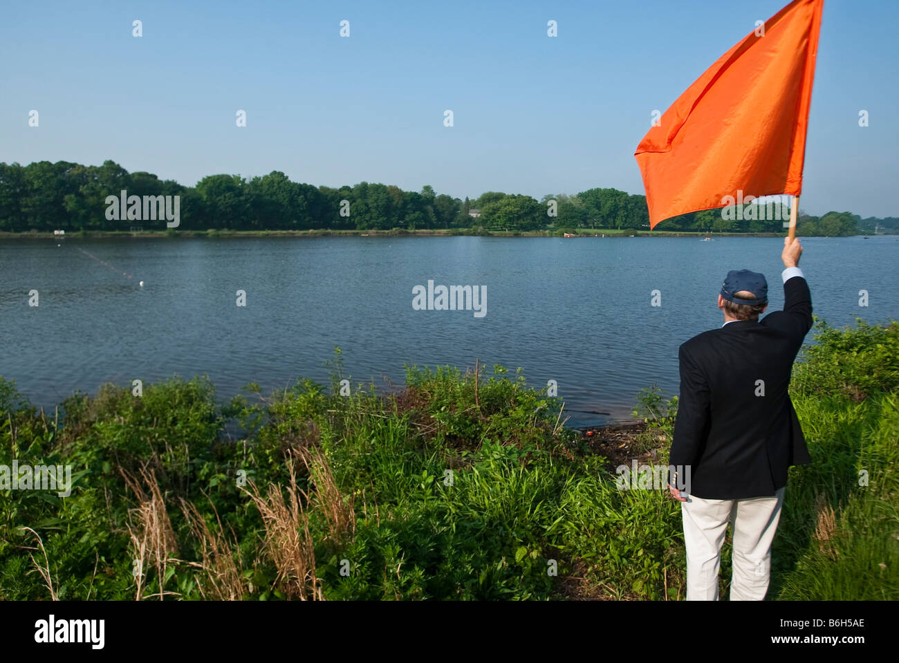 Man holding up a red flag to start a race Stock Photo - Alamy