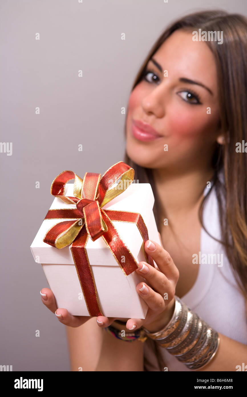 Attractive young woman offering a present Stock Photo - Alamy