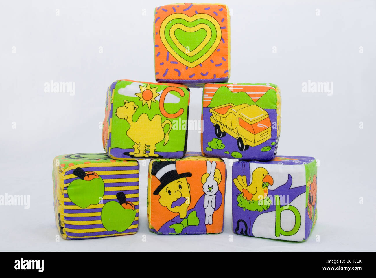 Six Colourful Material Baby Toy Blocks in a Triangular Stack on White ...