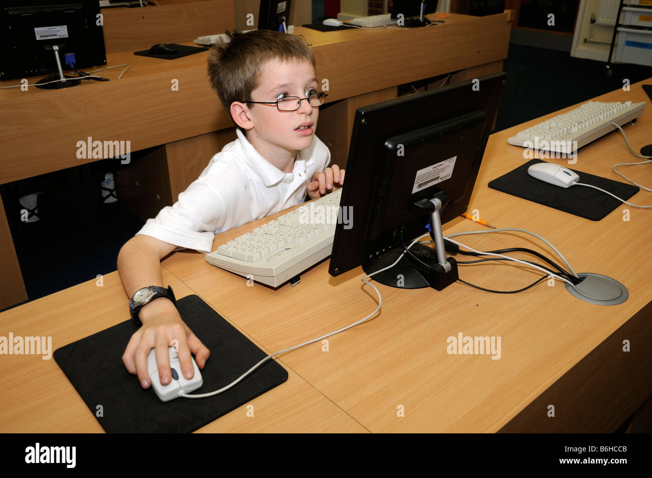 Primary school pupil using computer in classroom Stock Photo - Alamy