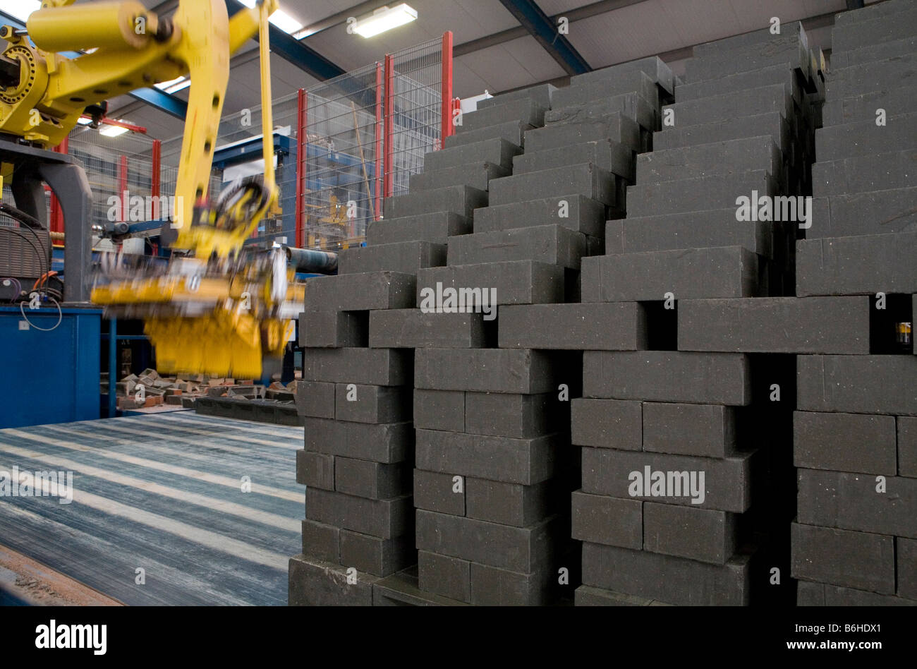 A robotic arm moves London Bricks as they come off the production line ...