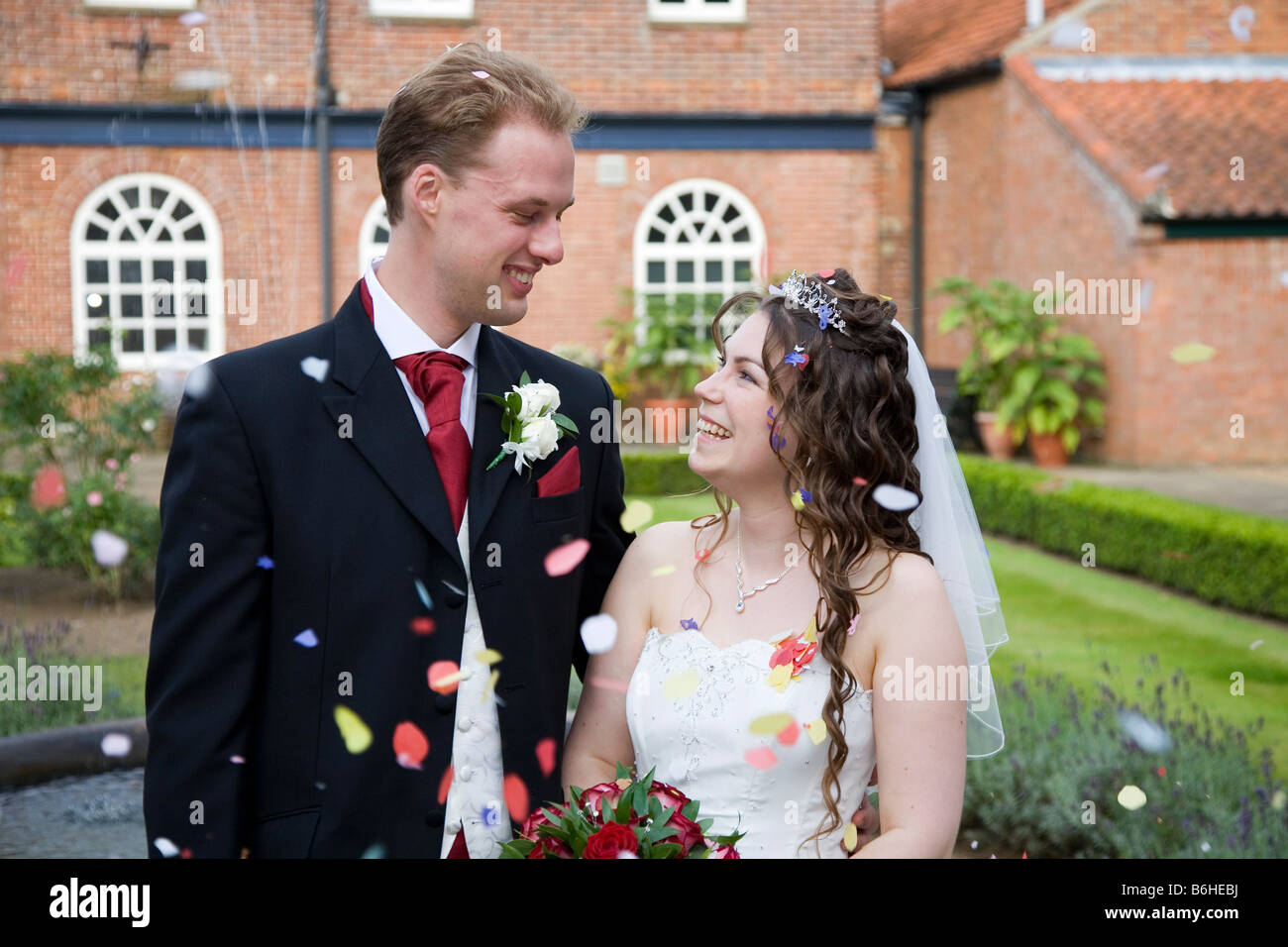 Wedding couple in confetti shower Stock Photo - Alamy
