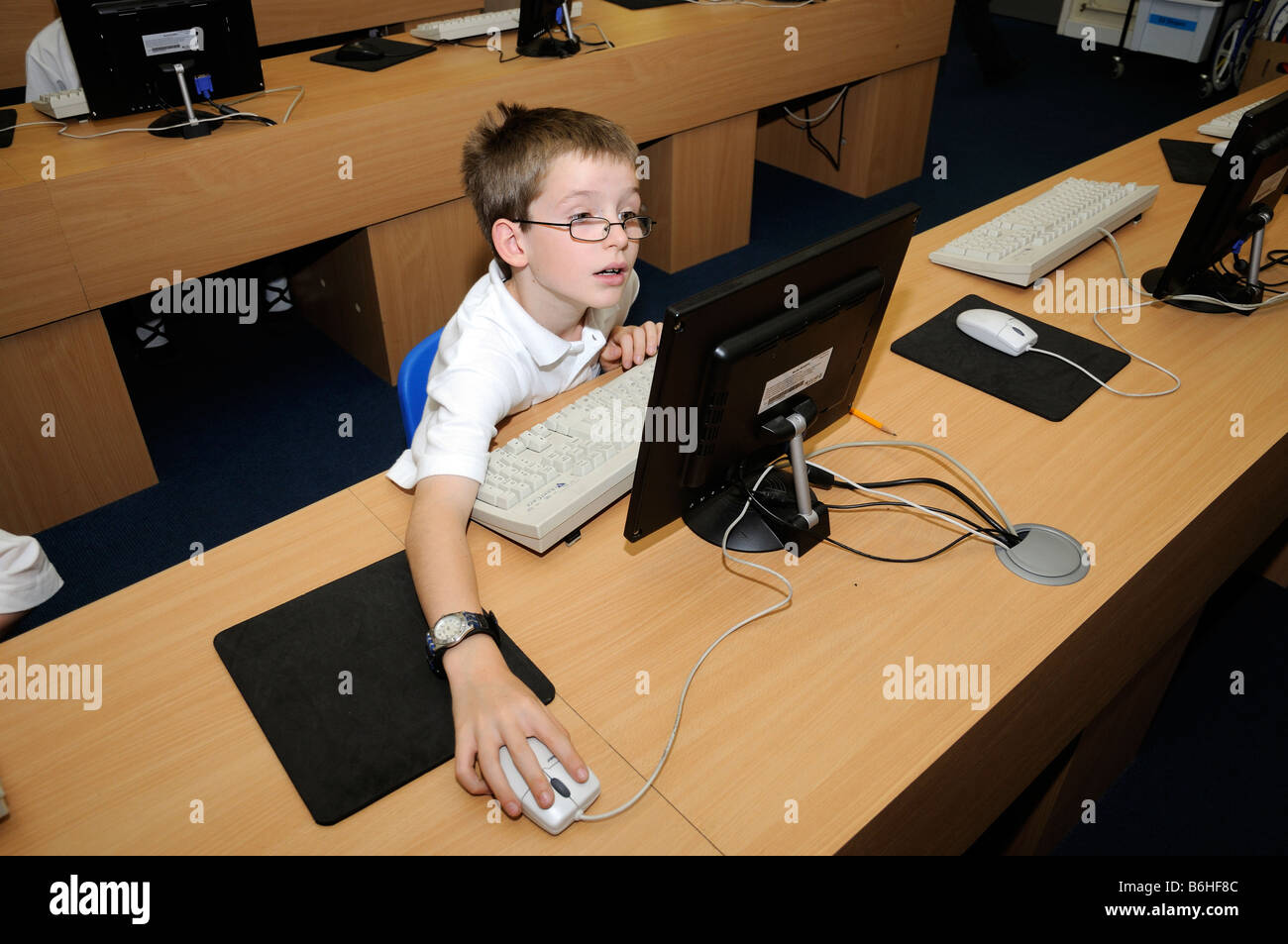 Primary school pupil using computer in classroom Stock Photo - Alamy