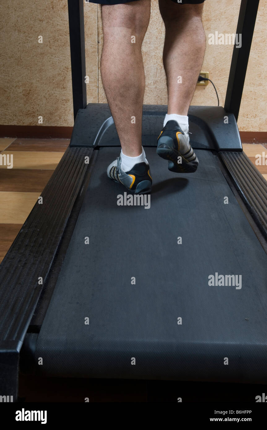 Rear view of a man exercising on treadmill Stock Photo - Alamy