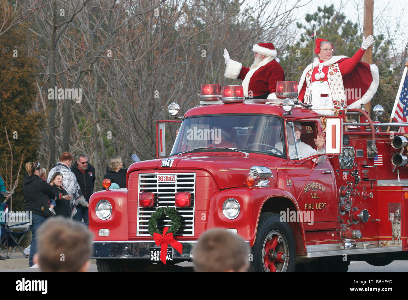 Santa Claus and Mrs Claus ride in on an antique 1960 fire truck at a ...