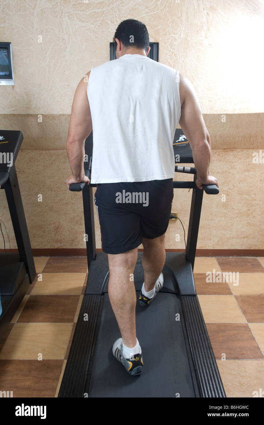 Rear view of a man exercising on treadmill Stock Photo - Alamy