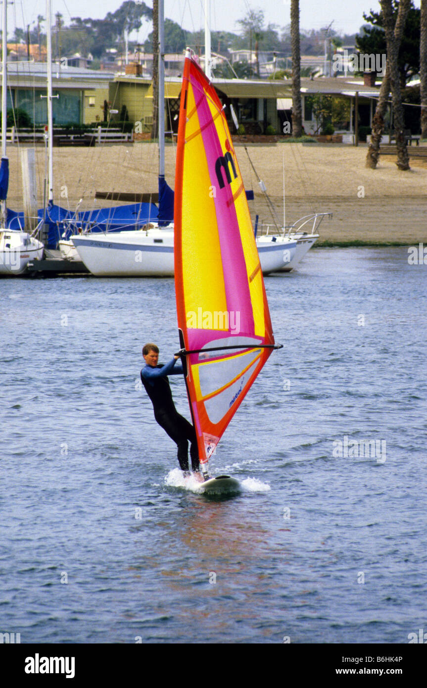 Windsurfer rides board on smooth waters of Newport Bay in southern ...