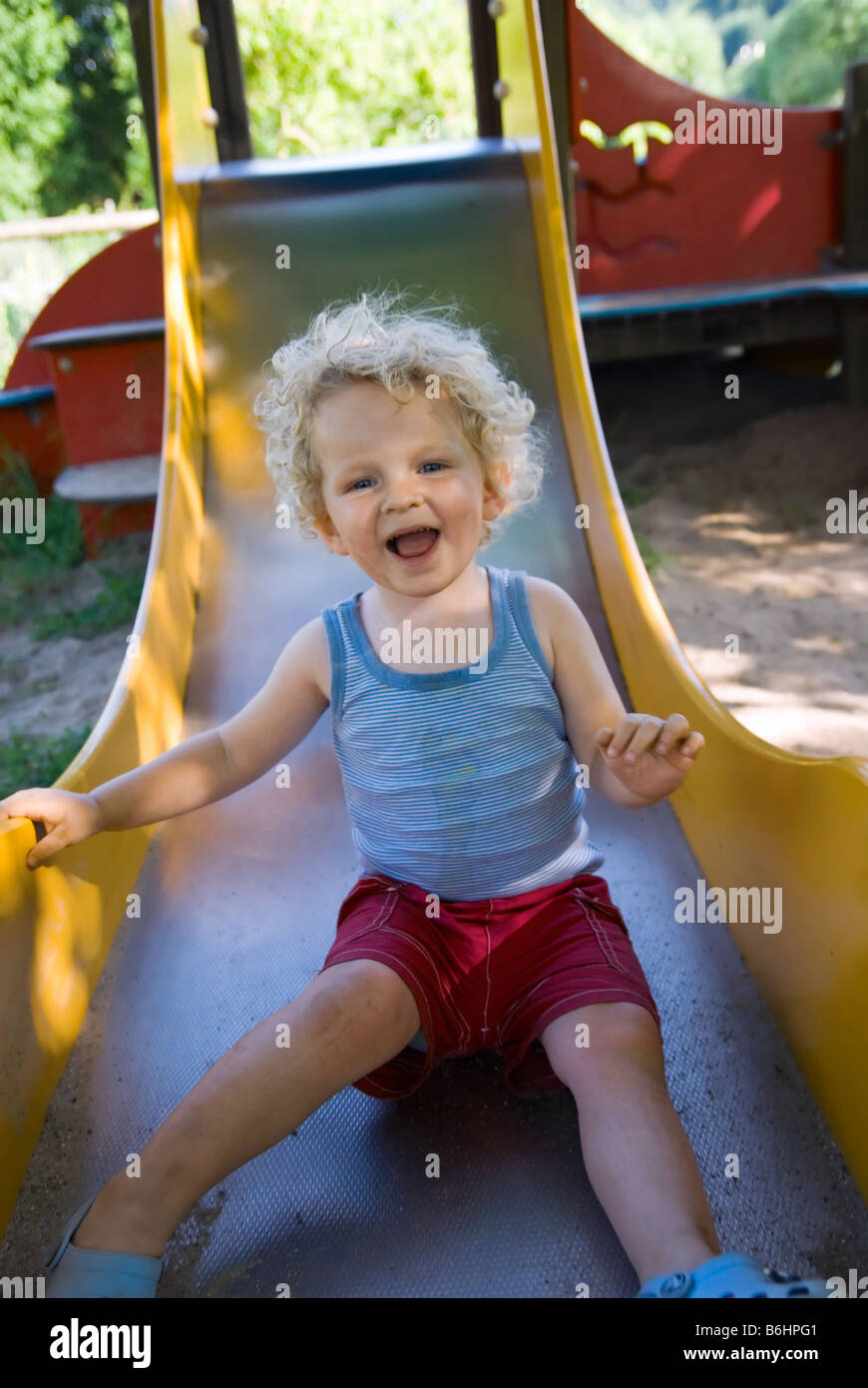 cute boy on a slide at the playground Stock Photo - Alamy
