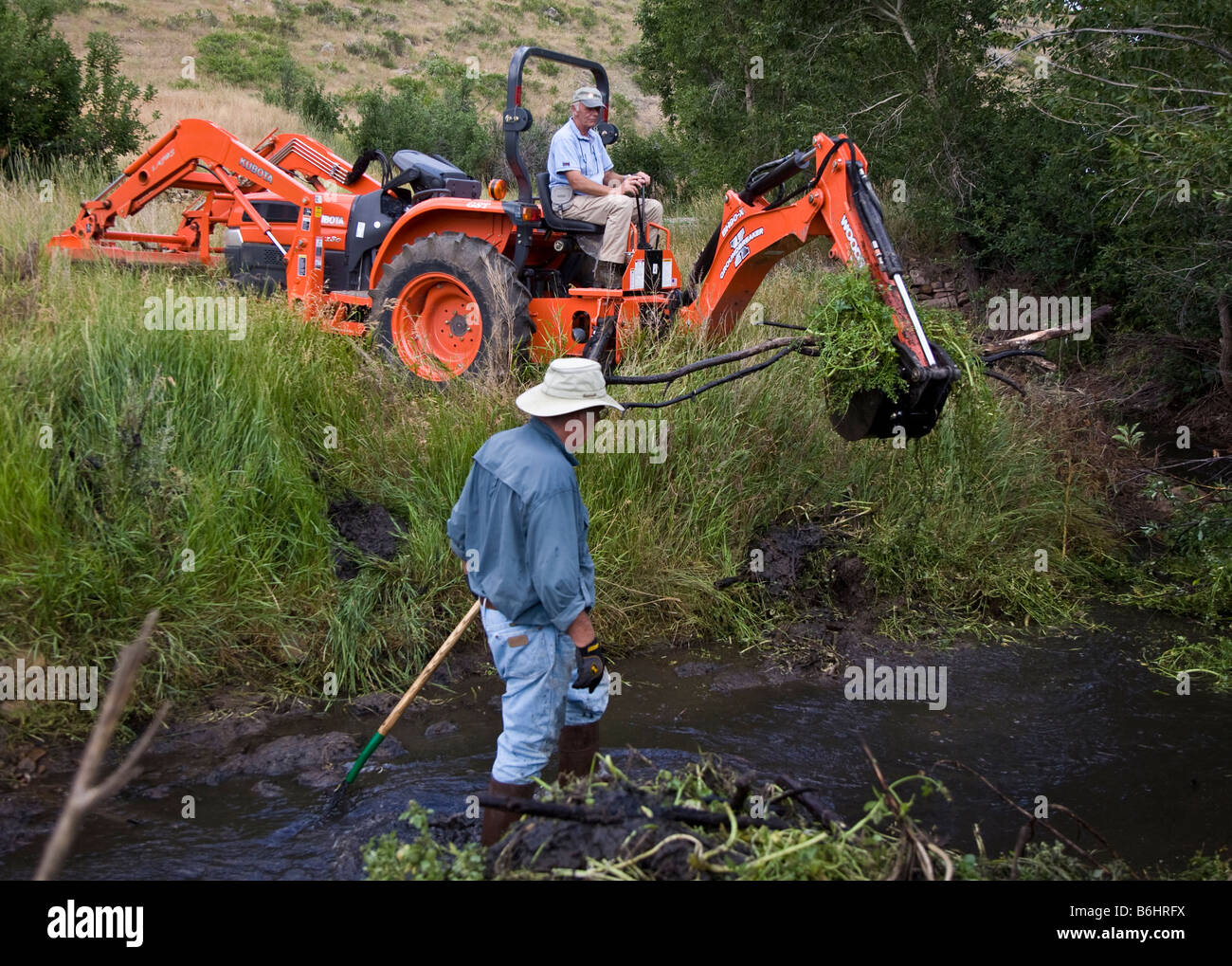 Man operating a Kubota tractor with backhoe Stock Photo - Alamy