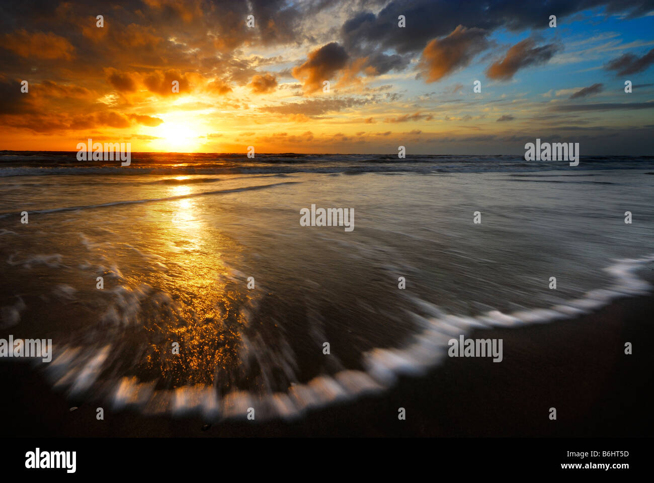 beautiful sunset and waves on the beach Stock Photo - Alamy