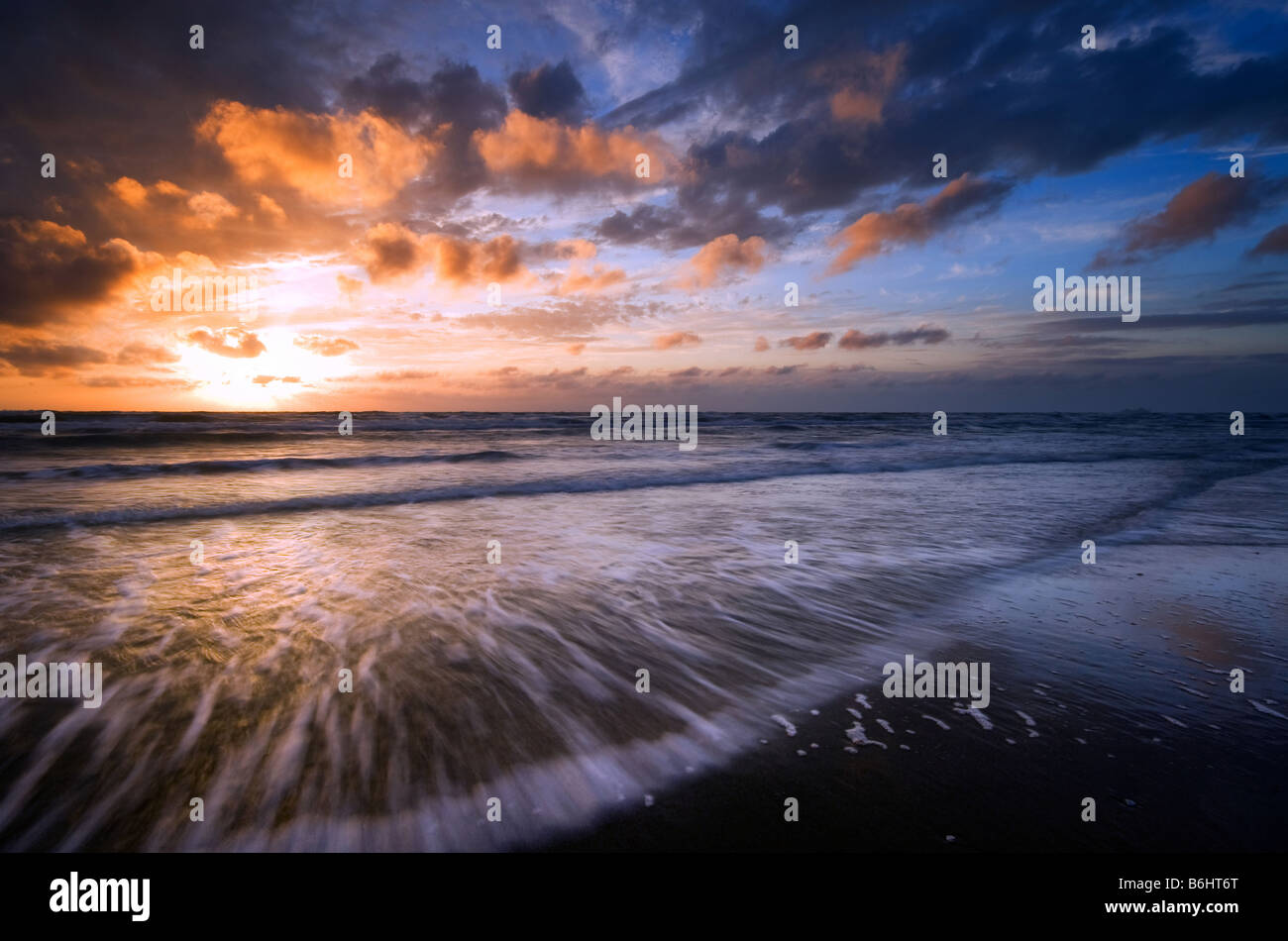 beautiful sunset and waves on the beach Stock Photo - Alamy