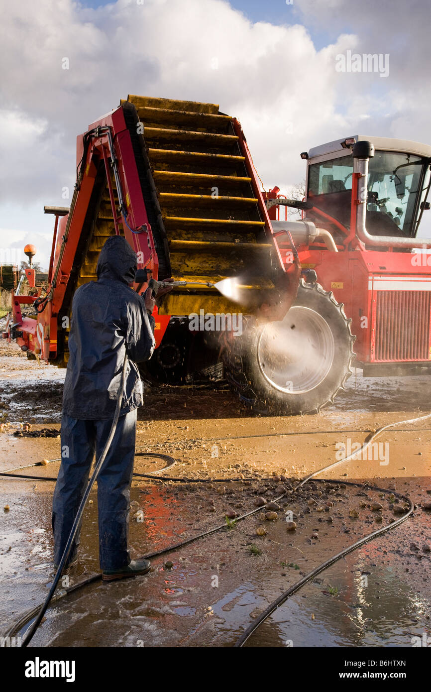 A farmer pressure washing a potato harvester Stock Photo - Alamy