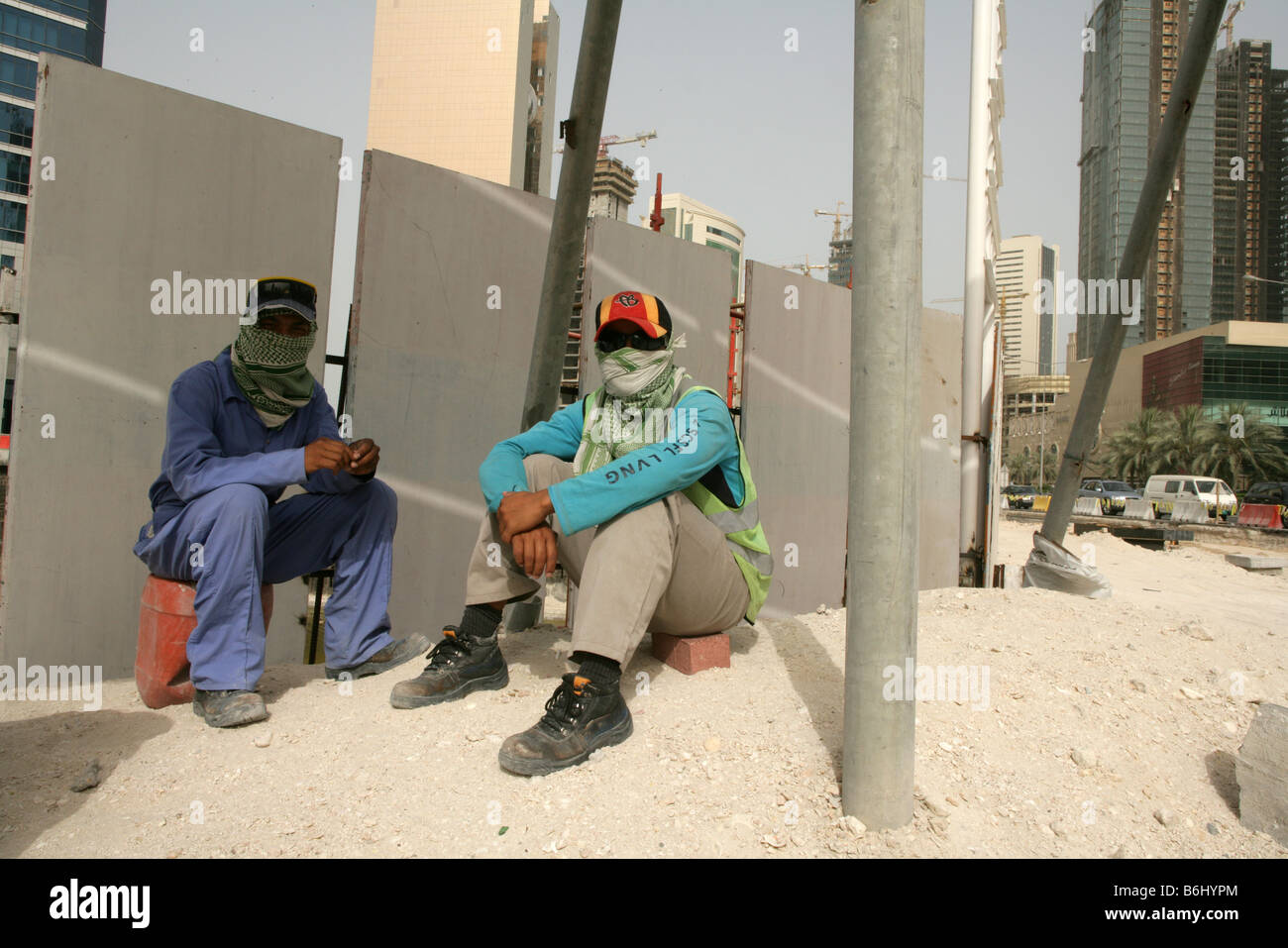 Migrant construction workers on construction site wearing sunglasses ...