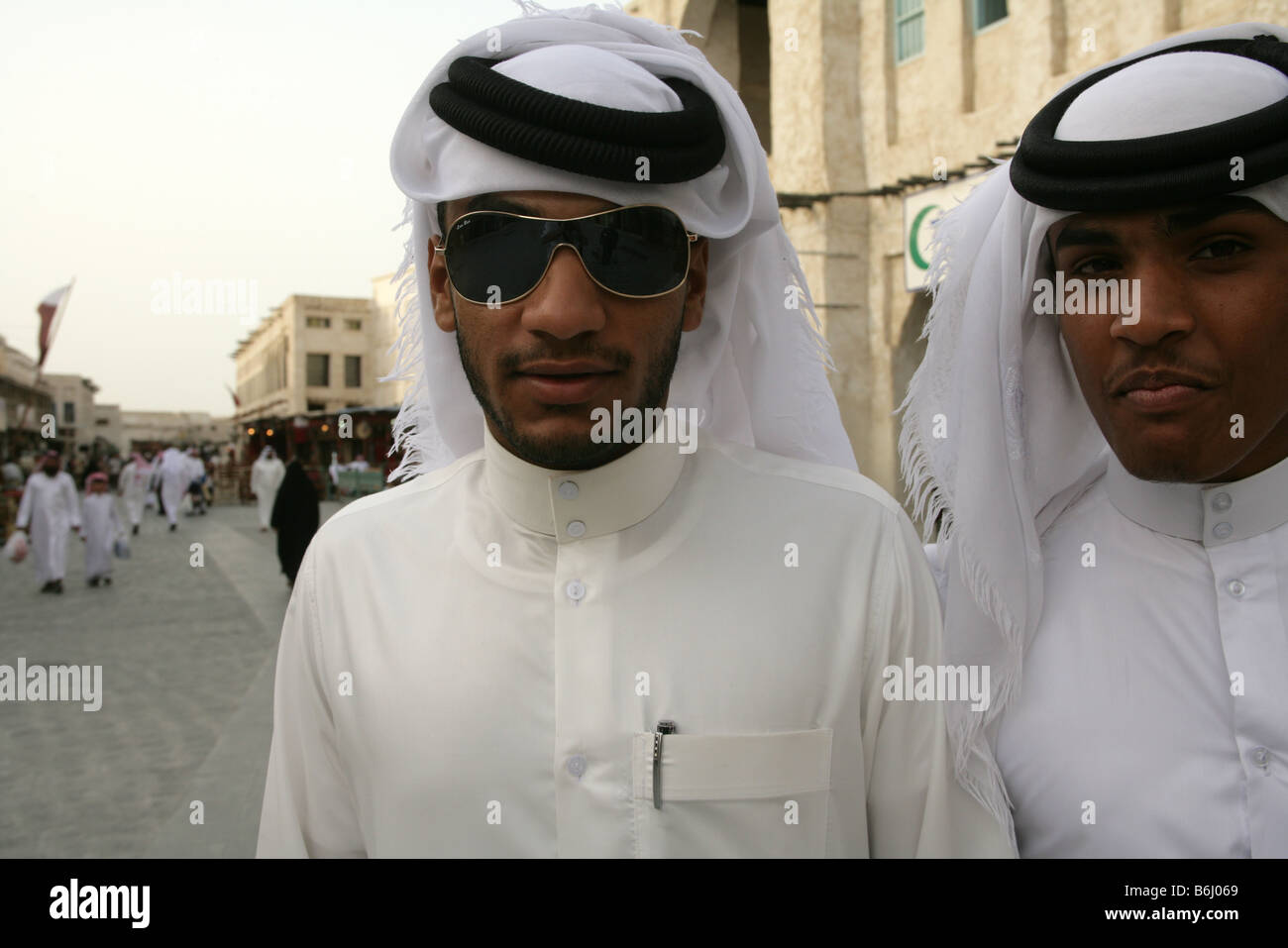 Qatari men in traditional clothing at the Souq Waqif market, head and ...