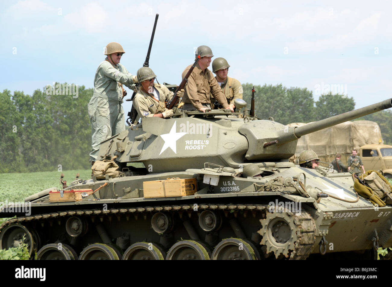A soldier on top a tank in a field during a World War II reenactment in ...