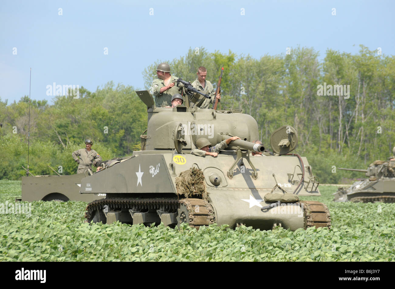 A soldier on top a tank in a field during a World War II reenactment in ...