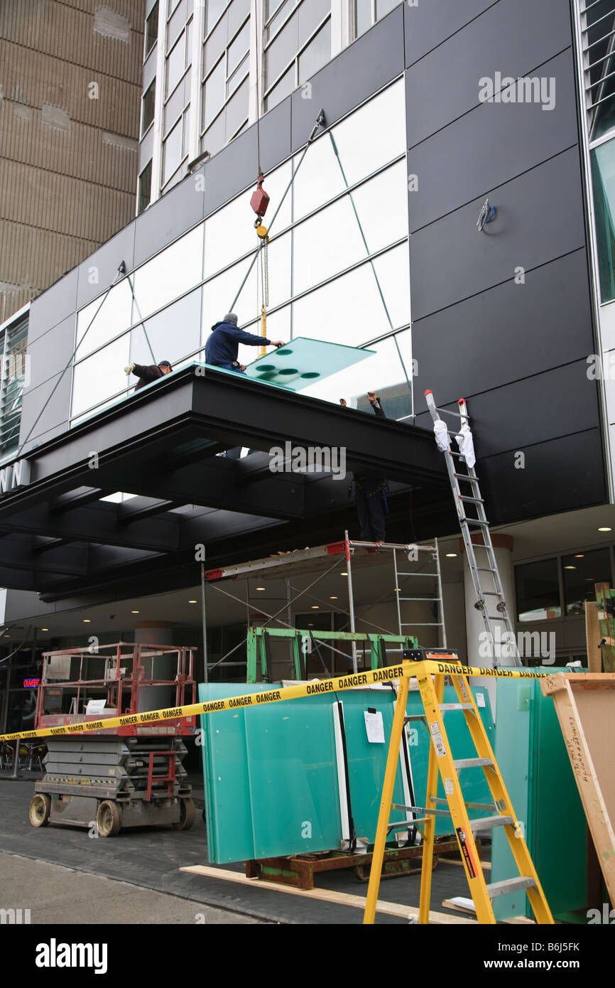 Workmen installing large glass panels in hotel Montreal Quebec Canada ...