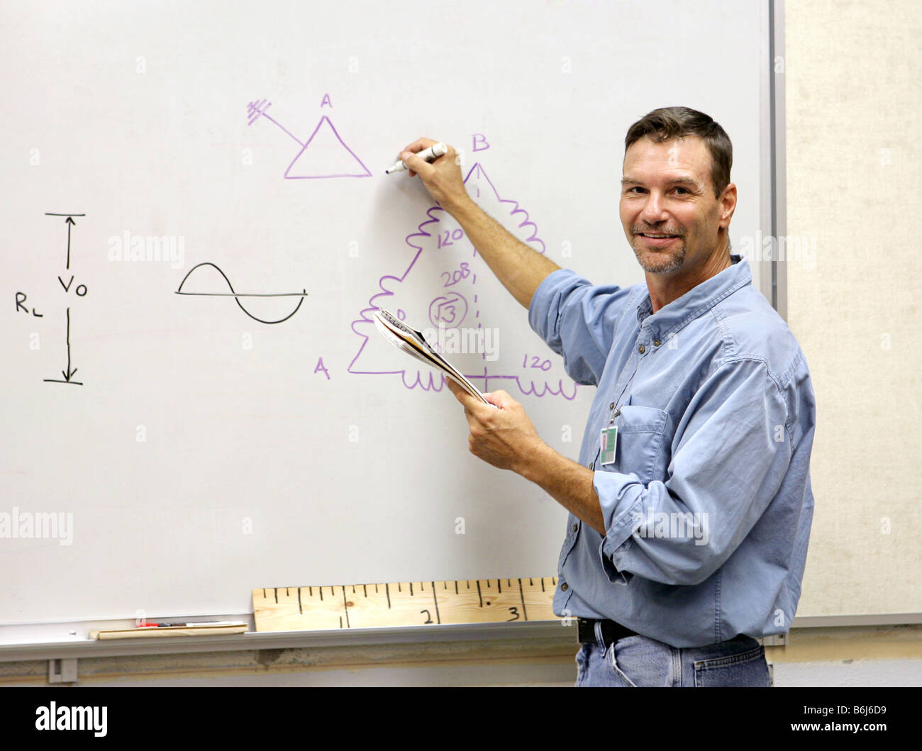 A handsome teacher drawing a mathematical diagram on the white board ...