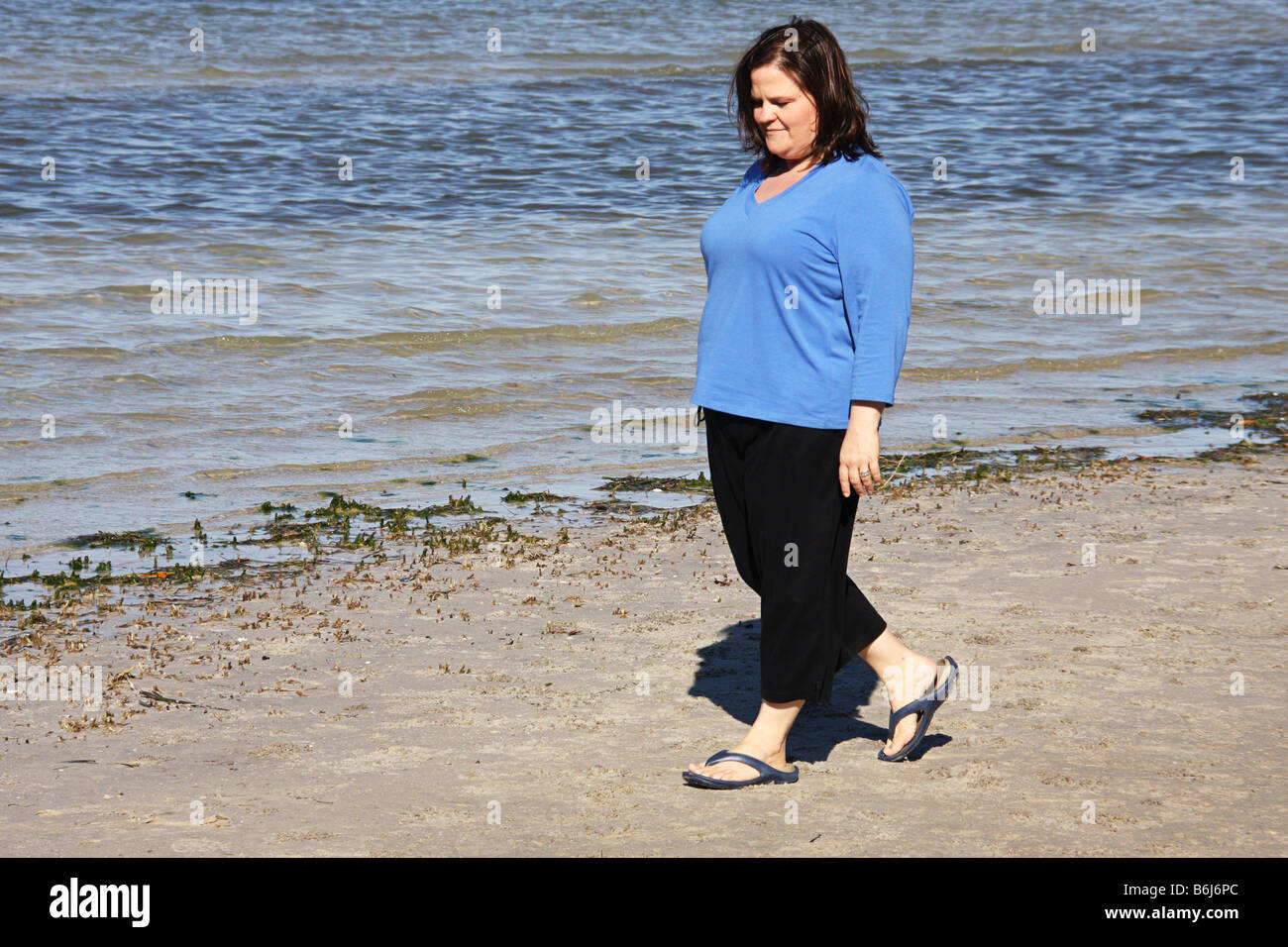 Beautiful plus sized model taking a walk by the sea Stock Photo - Alamy