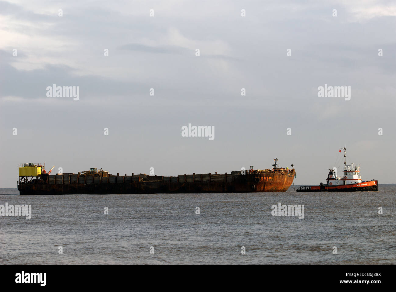 Barge under tow from a tug in the North Sea off the Suffolk coast, UK ...