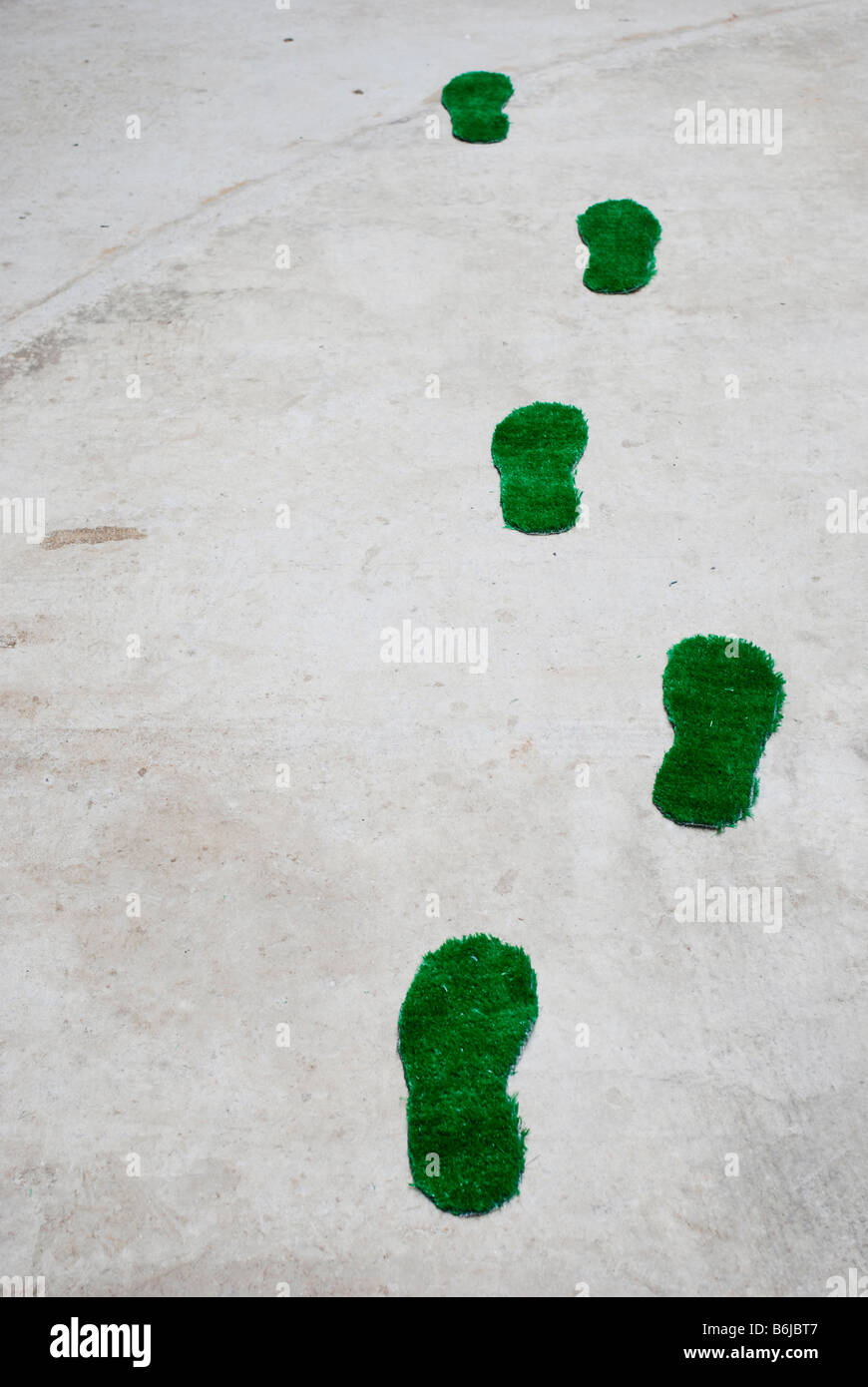 Green footprints over a concrete floor Stock Photo - Alamy