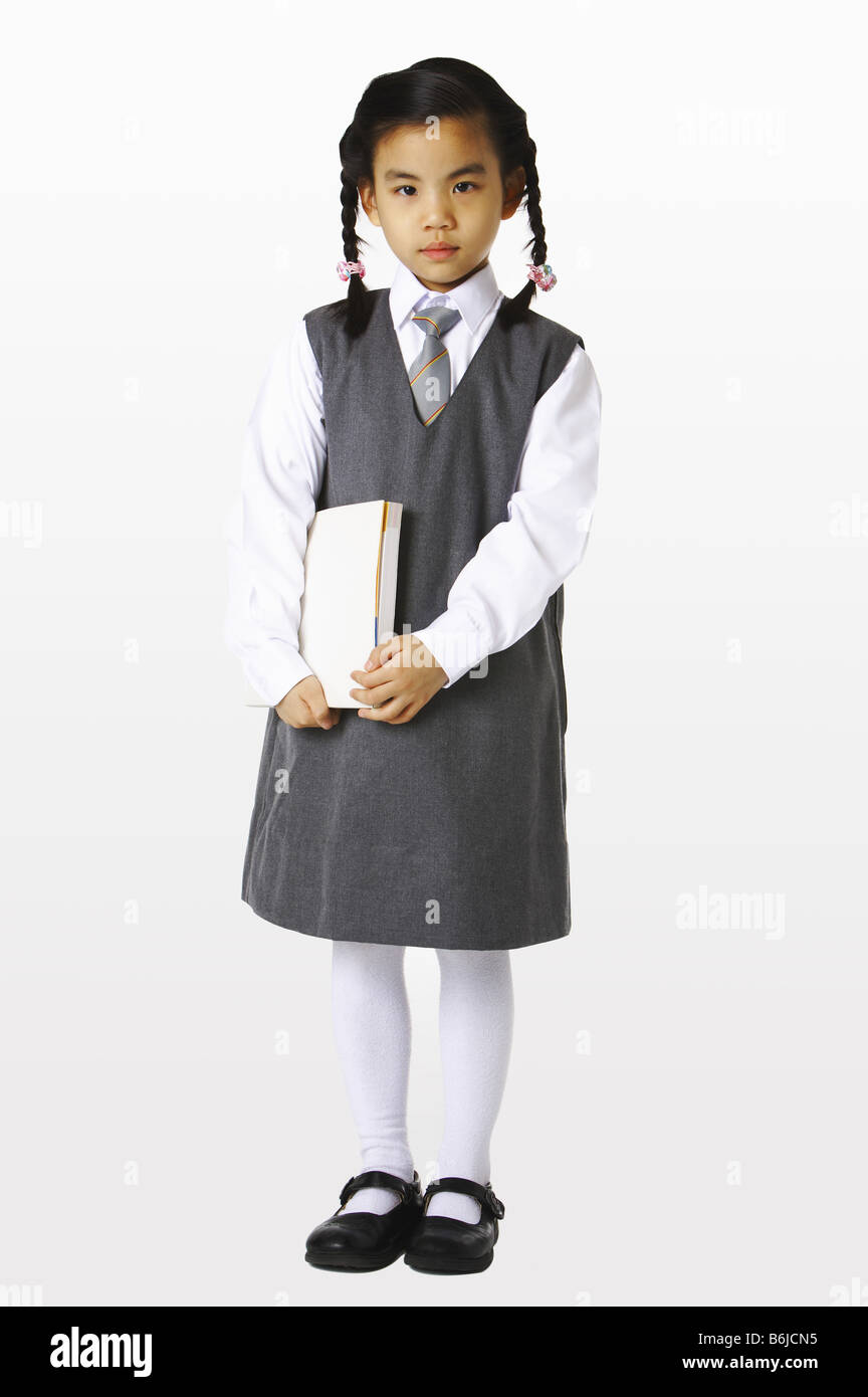 Girl in school uniforms holding a book Stock Photo - Alamy