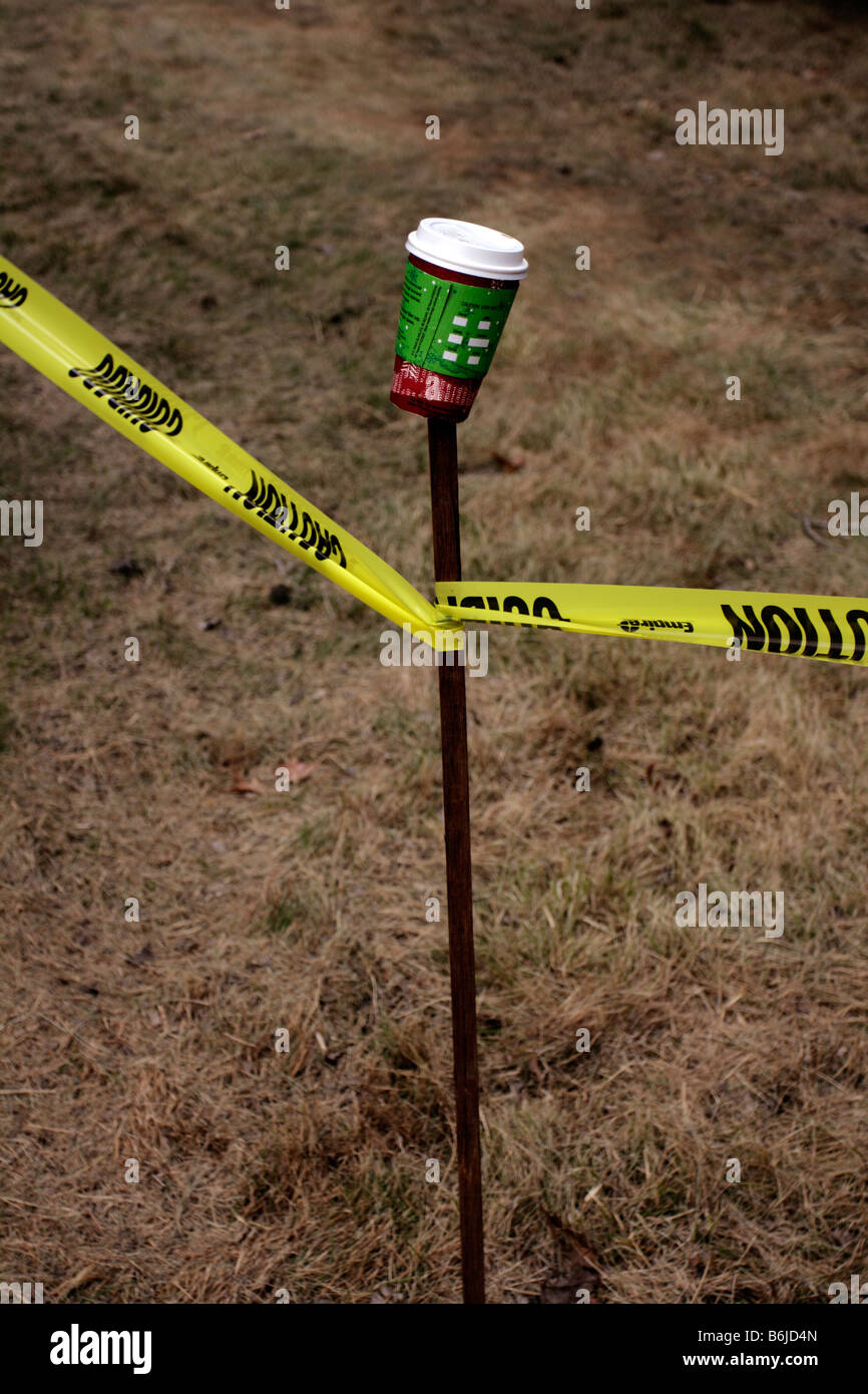 Styrofoam cup on top of boundary of yellow caution tape Stock Photo - Alamy